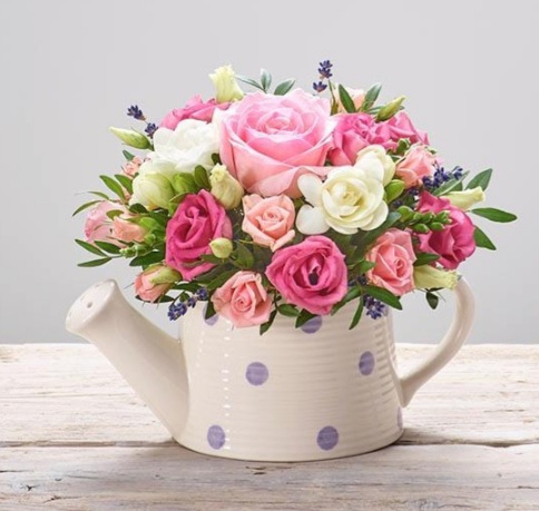 Cute watering can with pink and white flowers